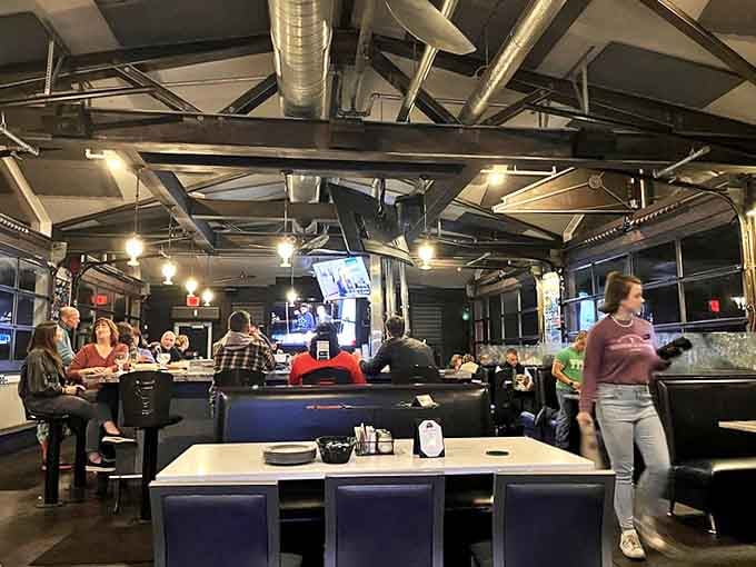 The industrial-chic interior balances historic charm with modern comfort, where exposed beams and string lights create inviting ambiance.