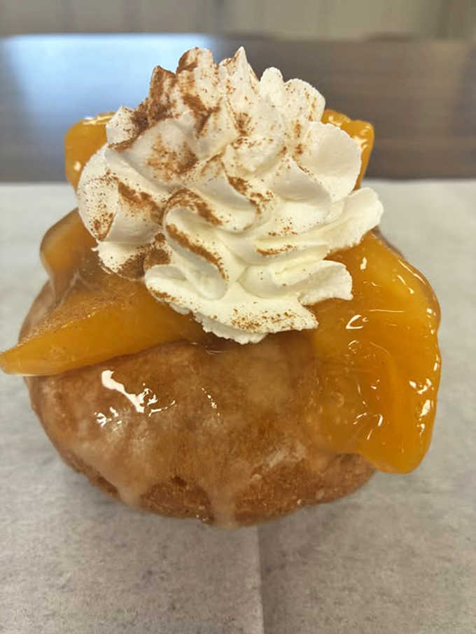 The Spiced Peach Pie Cake Donut &ndash; summer captured in pastry form, with fruit, spice, and everything nice, topped with a cloud of whipped cream.