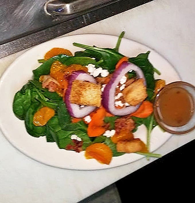 Garden-fresh spinach adorned with colorful companions and house-made dressing on the side. A thoughtful touch that lets you control your destiny.
