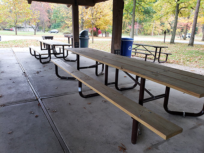 Simple wooden tables await beneath rustic shelter, where picnickers can dine like royalty with castle views.