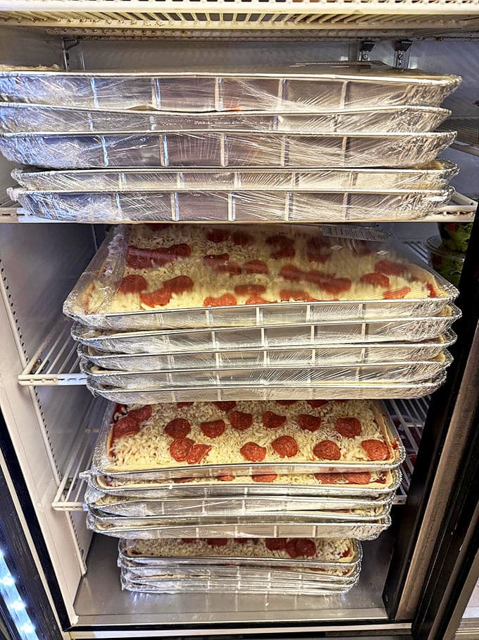 Take-and-bake pizzas stacked and ready for you to be the hero of dinner tonight without actually doing the hard part yourself.