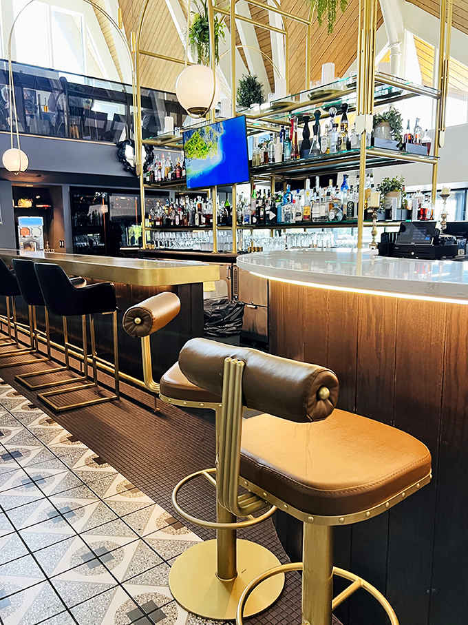 The bar area gleams with golden accents and premium spirits, promising libations crafted with the same care and attention as the cuisine.