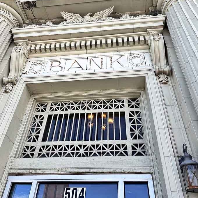 The word "BANK" still carved in stone above the entrance reminds passersby of serious financial history, now serving much tastier purposes daily.