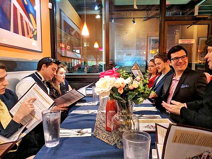 Diners gather around a beautifully set table, menus in hand, participating in the timeless ritual of deciding between sweet or savory breakfast bliss.
