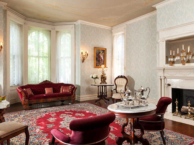 Crimson velvet meets delicate wallpaper in this parlor where you'll feel compelled to discuss literature or perhaps practice the pianoforte.