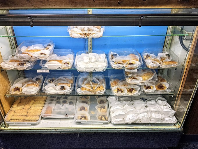 The dessert case – a glass-enclosed temple of temptation featuring baklava, galaktoboureko, and other sweet Greek treasures.