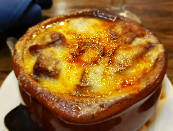 French onion soup, bubbling with cheese, waiting to reveal its savory secrets beneath that golden crust.