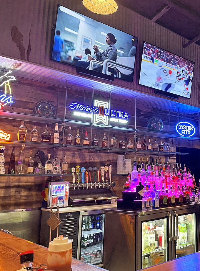 A bar stocked with enough spirits to raise your own, complete with the soft glow of neon that makes everyone look like they're on their second honeymoon.