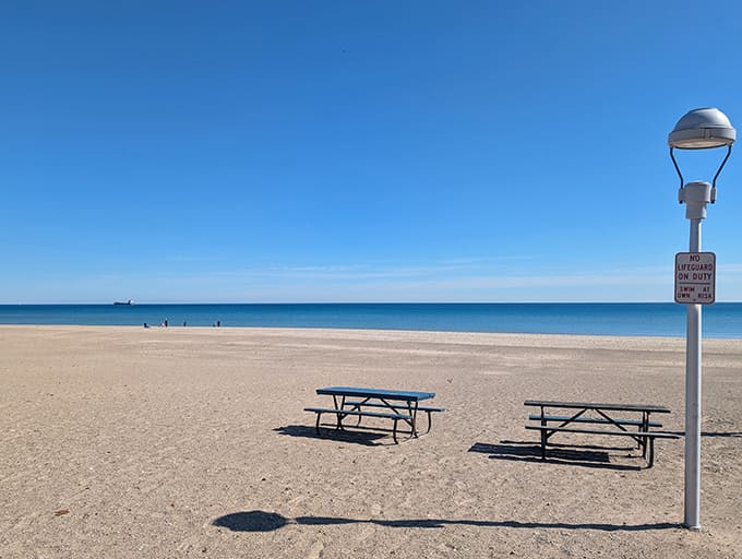 Beach furniture sits ready for picnickers who understand that food tastes exponentially better when consumed with a water view and a breeze.