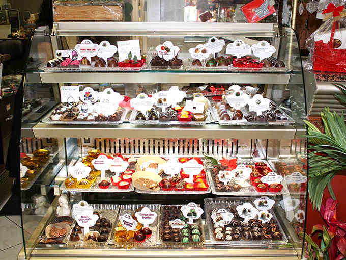 Behind glass, chocolate treasures await discovery &ndash; each tray offering a different journey for your taste buds to embark upon.