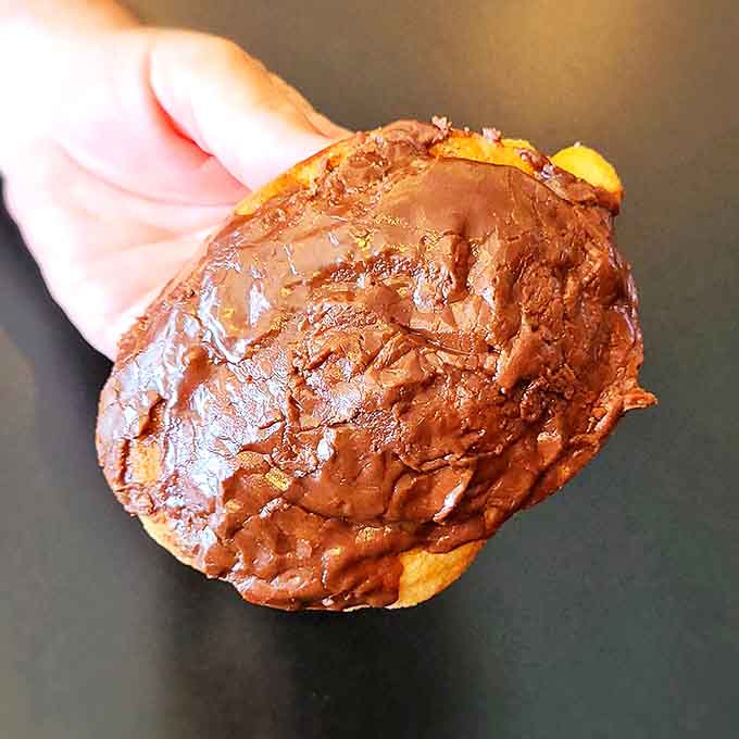 This chocolate-glazed donut isn't just breakfast&mdash;it's therapy in circular form, glistening with possibility and promises.