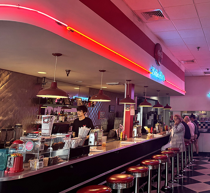 The counter seating area glows with neon nostalgia, inviting solo diners to perch and become part of the Nick's family.