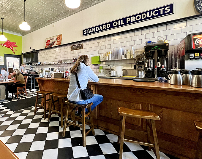 Counter seating offers front-row views of the kitchen ballet, where short-order magic happens beneath the vintage Standard Oil Products sign.