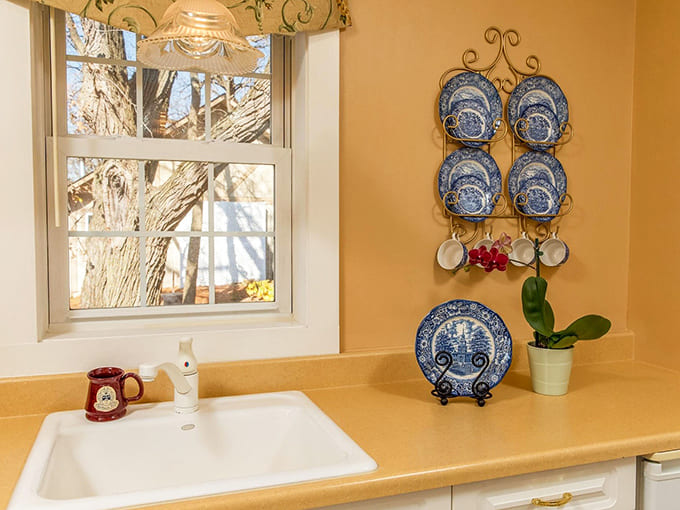 Blue willow plates add vintage charm to this sunny kitchen corner &ndash; grandmother's treasures meet modern convenience in perfect harmony.