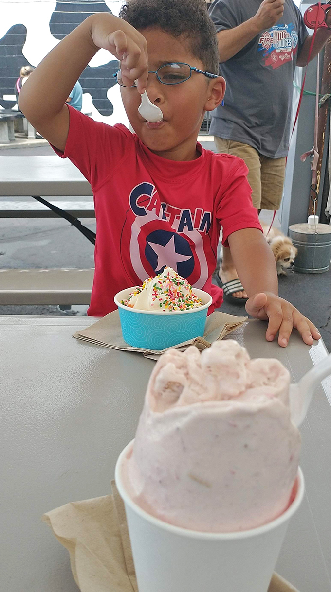 The pure joy of childhood captured in one perfect moment &ndash; sprinkles, superhero shirt, and the serious business of ice cream consumption.