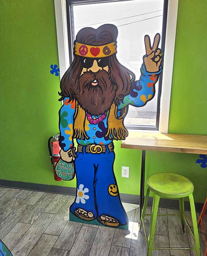 The shop's bearded, peace-sign-flashing mascot stands guard, silently approving your decision to indulge in these bite-sized circles of joy.