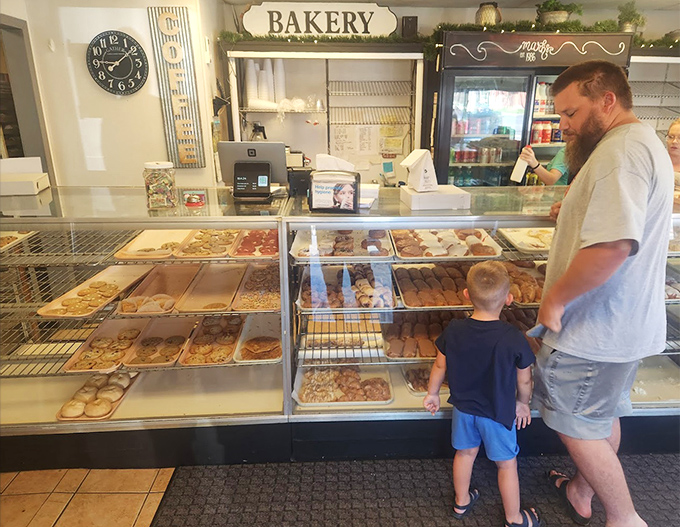 The timeless joy of choosing treats at a real bakery &ndash; a father and son making memories sweeter than any donut could be.