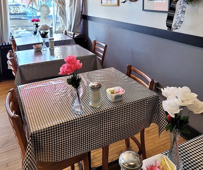Black and white checkered tablecloths and fresh flowers create a homey atmosphere where time slows down and conversations flow freely.
