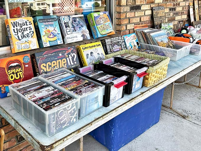 Sidewalk treasures beckon with board games, DVDs, and books, proving that sometimes the best finds happen before you even enter.