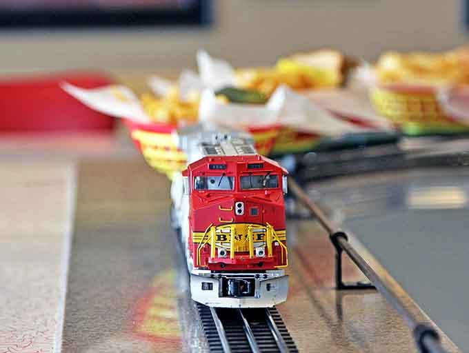 That detailed model train isn't just decoration but a hardworking employee, faithfully delivering meals with more reliability than some actual servers.