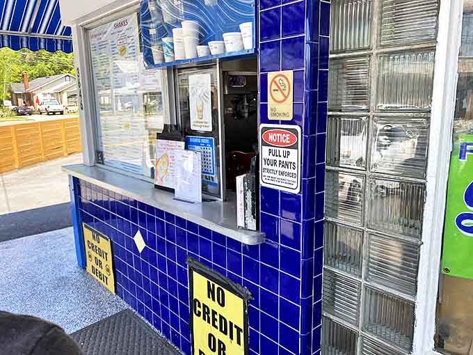 The blue-tiled order window, where dreams come true and diet plans go to die, complete with that charming "pull up your pants" reminder.