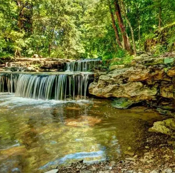 A gentle cascade creates nature's staircase &ndash; water tumbling over limestone that's been shaped by centuries of persistent flow.