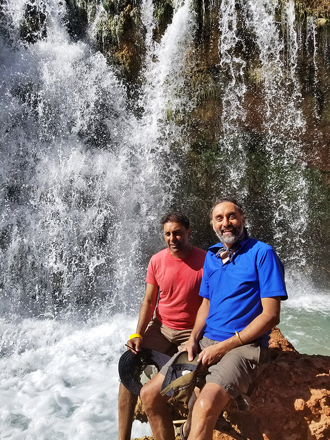 Hikers enjoying the fruits of their labor: After a challenging trek, the falls offer the perfect backdrop for celebration.