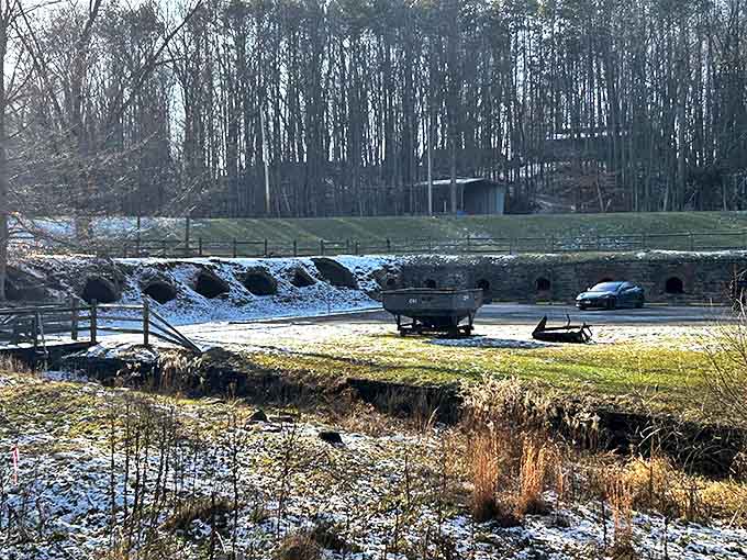 Winter transforms the ovens into snow-dusted industrial gingerbread houses, the stark contrast between white snow and blackened brick entrances particularly striking.