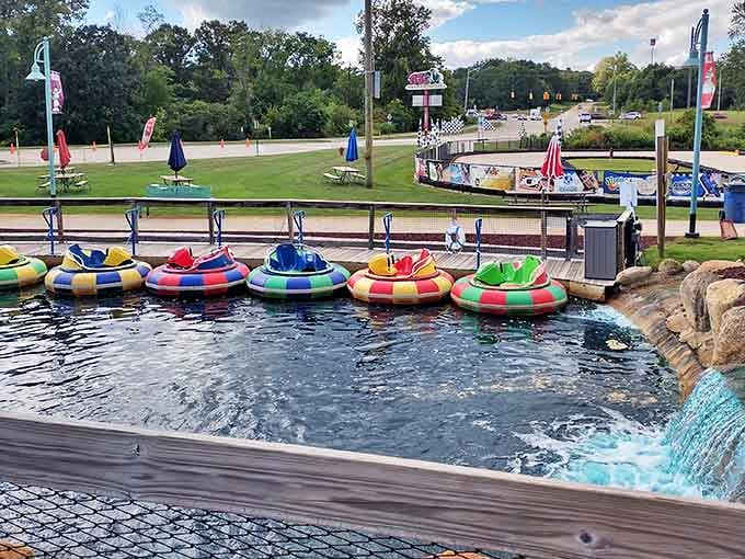 Colorful bumper boats await their captains, lined up like floating candy against the sparkling water that will soon become a splashing battleground.