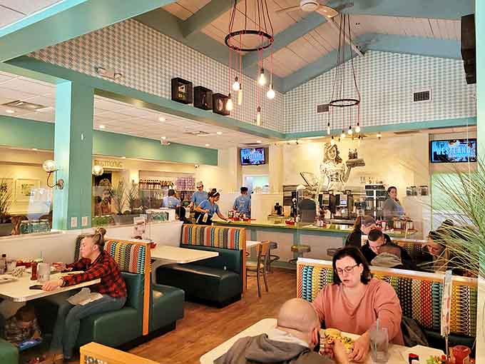 The dining area hums with conversation and clinking silverware &ndash; a symphony of satisfaction orchestrated by turquoise walls and pendant lighting.