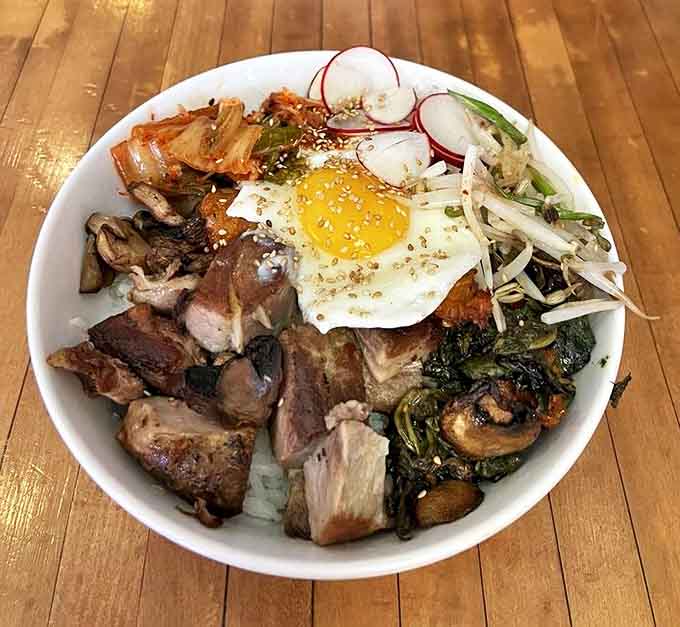 The signature Bowl-Bim-Bap arrives like edible art, crowned with a sunny egg just begging to be broken into deliciousness.