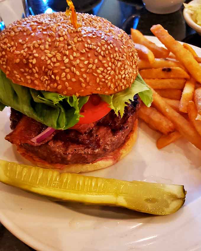 That sesame seed bun is working overtime holding together this juicy burger and its crispy fries sidekick.