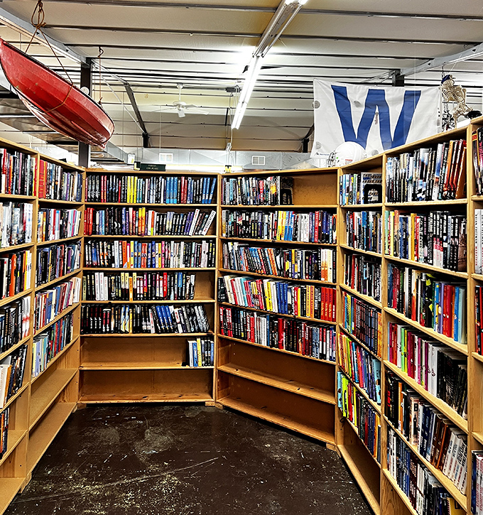 A curved aisle of fiction with a canoe hanging overhead—because good books, like good boats, transport you to places you've never been.