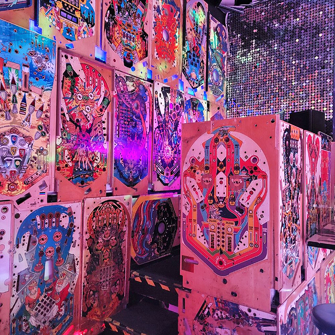 A mesmerizing wall of pinball playfields creates an immersive backdrop that transforms a simple meal into a multi-sensory experience.