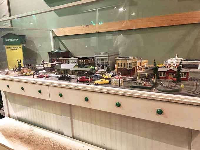 The detailed model train layout isn't just decoration&mdash;it's a fully functional miniature railway system that happens to deliver your dinner.