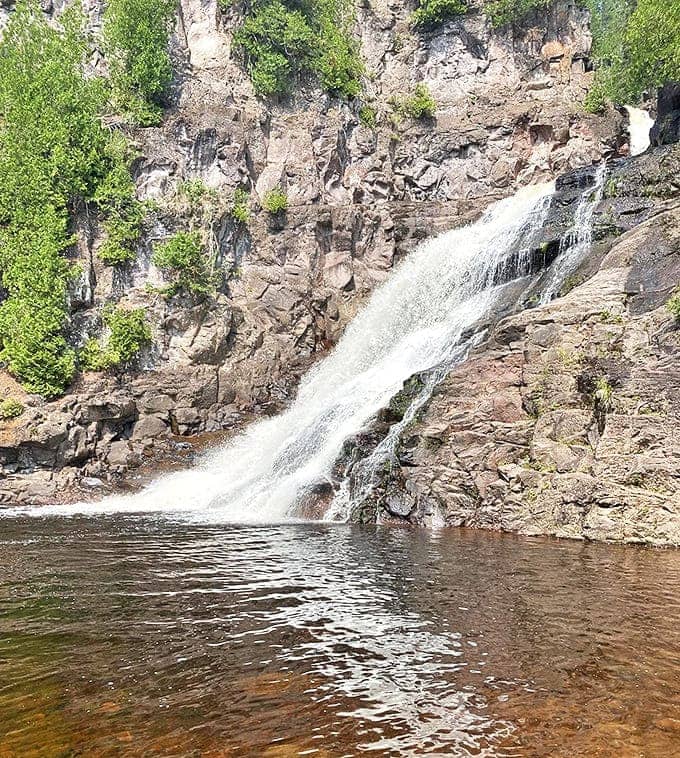 The waterfall's side profile reveals its powerful descent over ancient rock formations. Water has been sculpting this masterpiece for thousands of years.