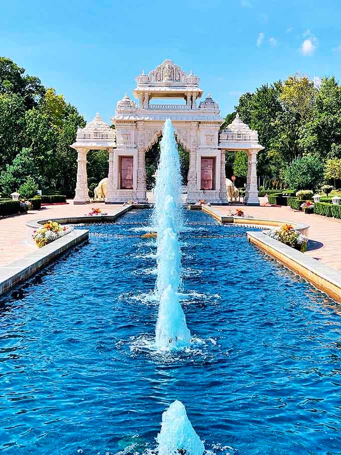 Crystal-clear water dances through this elegant fountain, creating a reflective pathway that draws the eye toward the temple's magnificent entrance.