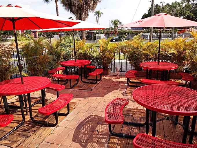 The outdoor patio's cheerful red tables create a tropical oasis where breakfast becomes an occasion rather than just a meal.
