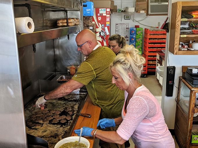 The kitchen crew works their flat-top magic, pressing each patty with practiced precision that comes from decades of burger craftsmanship.