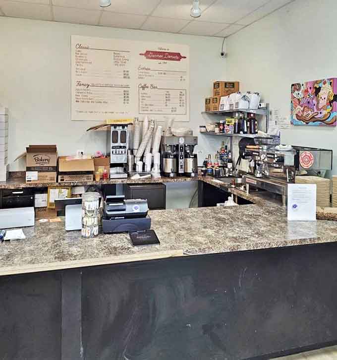 Command central for donut operations, where coffee machines hum and friendly staff orchestrate the morning rush with practiced precision.