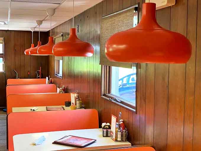 Distinctive orange pendant lamps cast a warm glow over the booths &ndash; retro lighting that's original, not manufactured nostalgia.