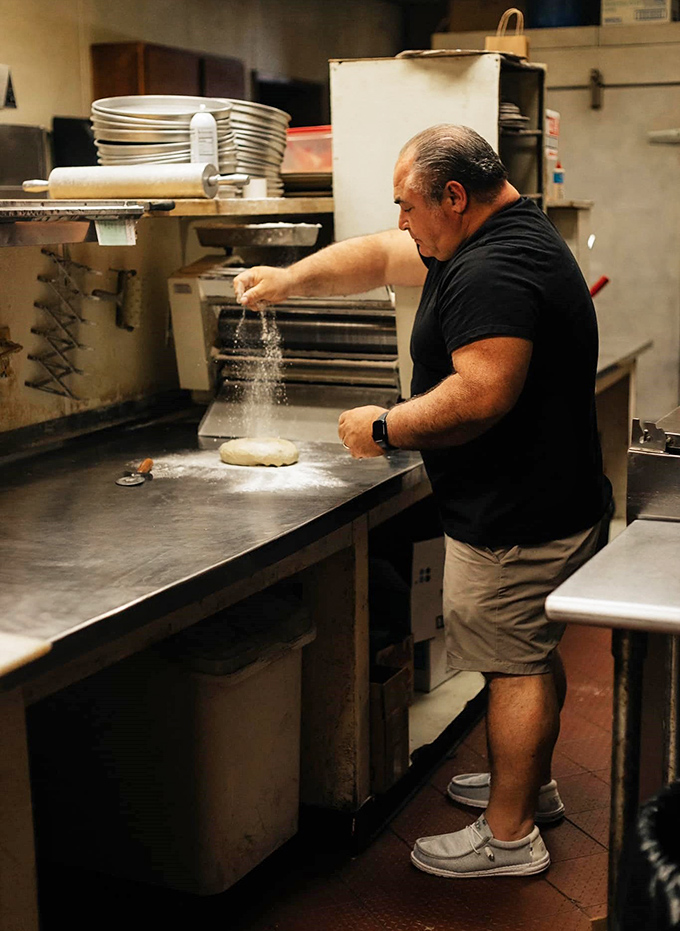 The pizza maestro at work &ndash; decades of experience in every sprinkle of flour and stretch of dough.