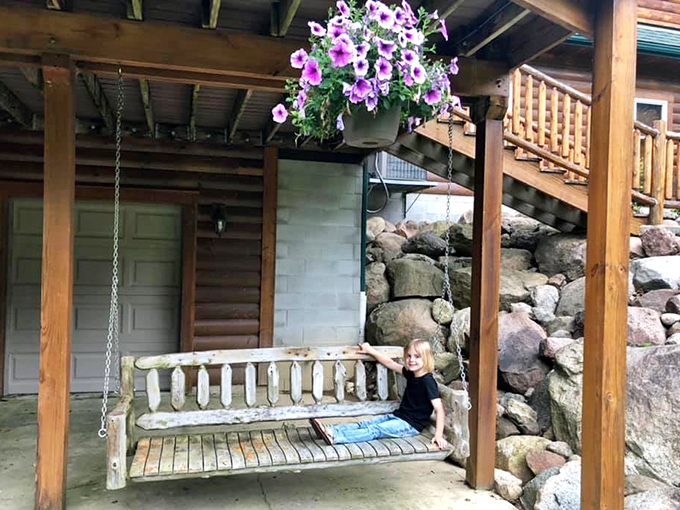 A porch swing invites unhurried moments beneath flowering baskets, proving that sometimes the simplest pleasures deliver the greatest joy.