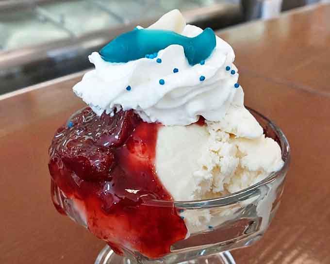 The Shark Week Sundae brings together creamy vanilla ice cream, tart strawberry topping, and a blue gummy shark that's somehow both menacing and delicious.