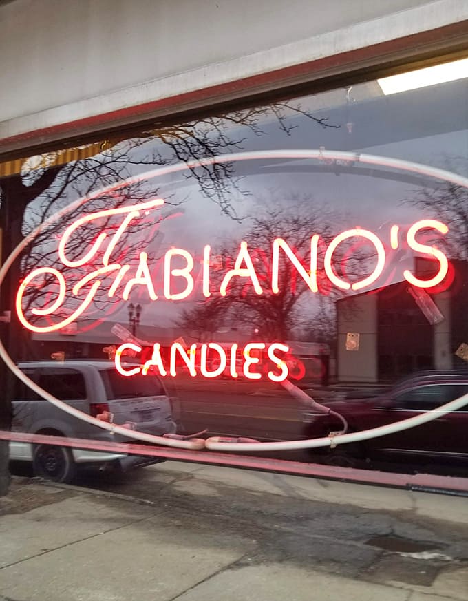 The Fabiano's sign glows with the promise of handmade chocolates and nearly a century of confectionery expertise waiting just beyond the door.