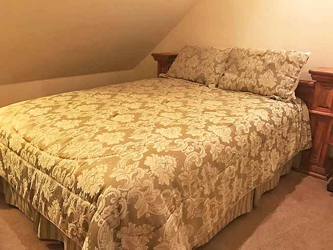 Floral bedding and sloped ceilings create an unexpectedly cozy atmosphere in this upper-level room where comfort trumps the building's stern past.