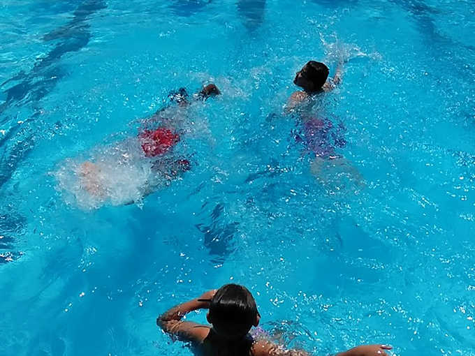Aquatic choreography: Swimmers create their own water ballet in the crystal-clear pool, where summer's soundtrack is equal parts splash and laughter.