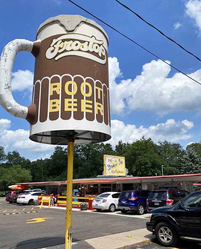 The iconic root beer mug stands tall against blue skies, a beacon calling to anyone who appreciates the finer things in life.