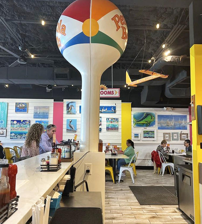A colorful beach ball water tower serves as the restaurant's quirky centerpiece, hovering above diners enjoying their Gulf Coast feast.