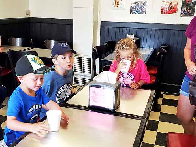 Young ice cream enthusiasts demonstrate the proper technique for savoring summer's sweetest moments at Tip Top.